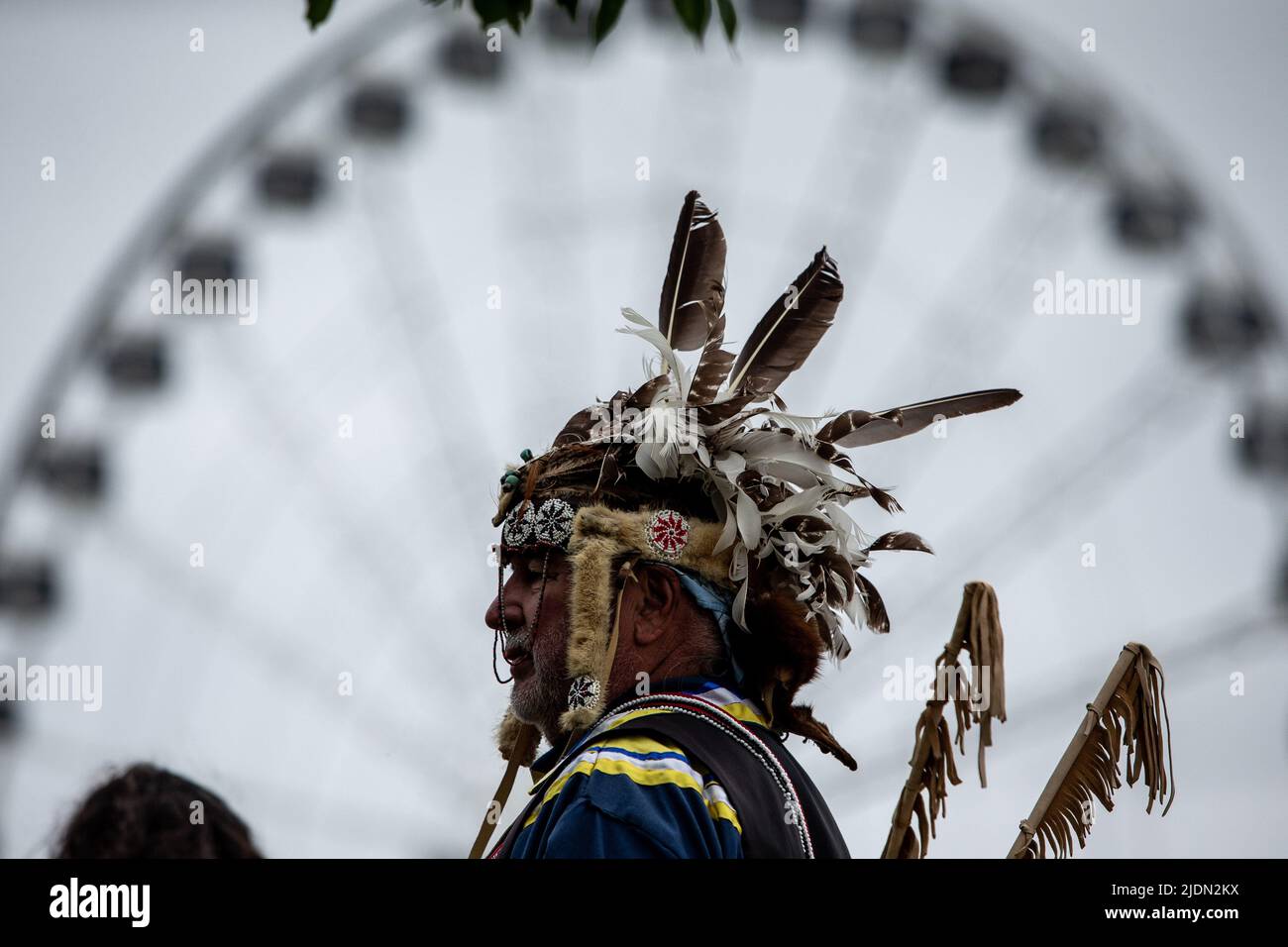 A Mohawk elder wearing his traditional feather headdress in front of La ...