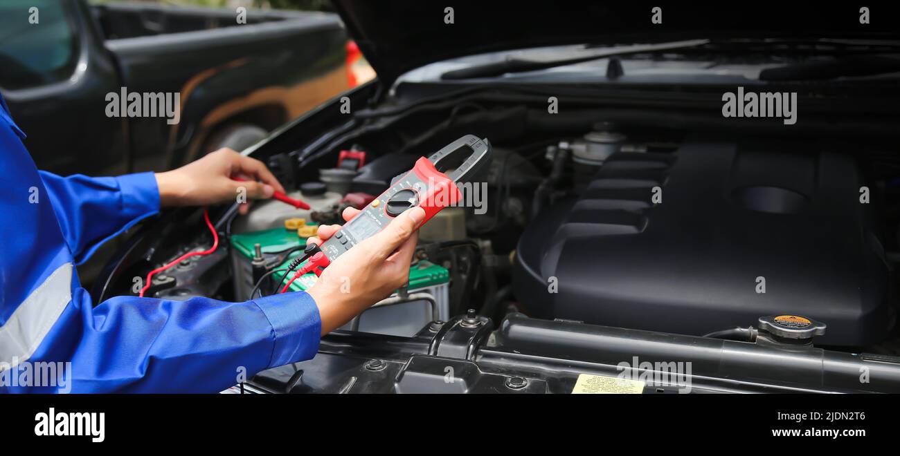A technician is checking the car battery for availability Stock Photo ...