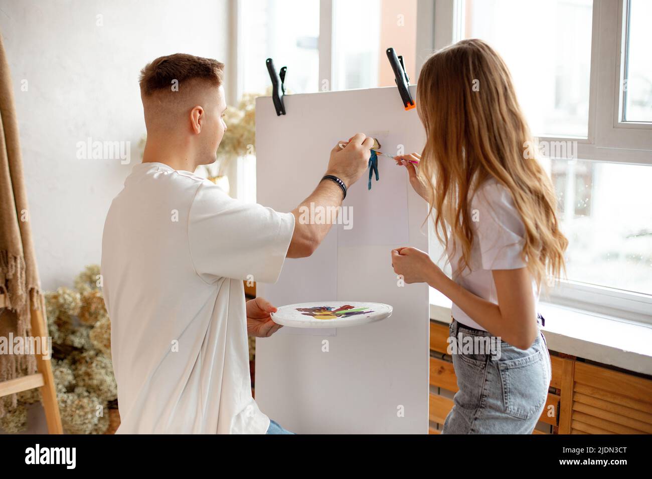 Young couple drawing together. Wife and husband painting on canva and ...