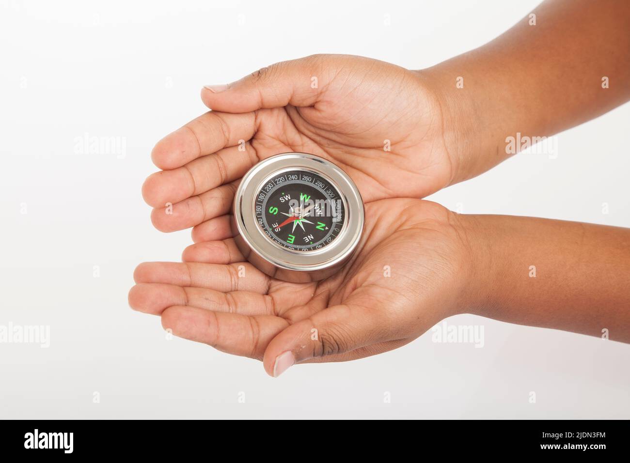 Child hands holding a compass on white background Stock Photo - Alamy