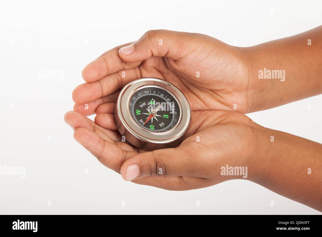 Child hands holding a compass on white background Stock Photo - Alamy
