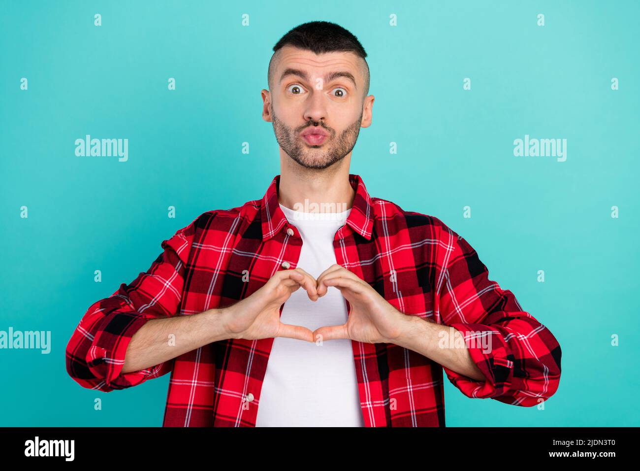 Photo of cheerful charming flirty young man show fingers small heart ...