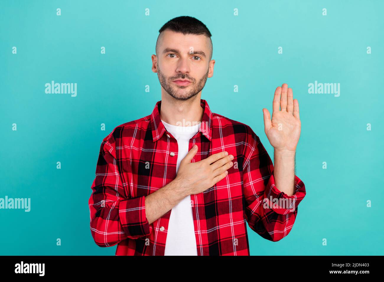 Photo of serious young calm honest man hold hand chest heart make oath ...