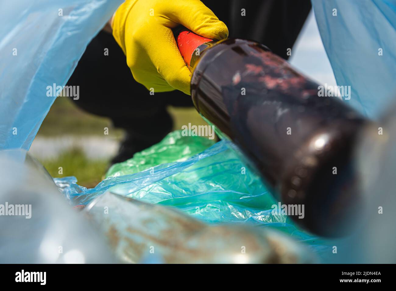 Close-up of a hand throwing garbage into a plastic bag. View from ...