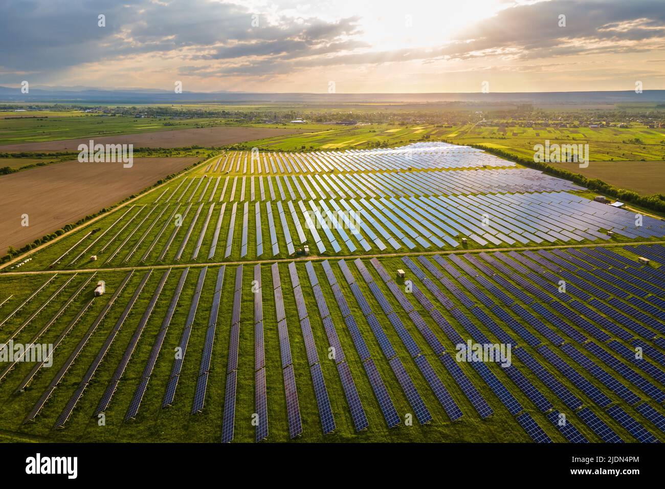 Aerial view of large sustainable electrical power plant with many rows of solar photovoltaic ...