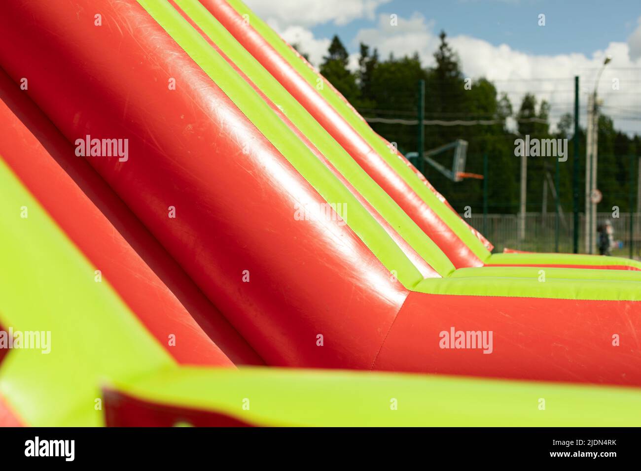 Inflatable slide of red color. Obstacle course in summer. Amusement ...