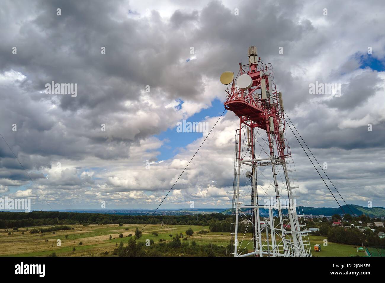 Aerial view of telecommunications cell phone tower with wireless communication antennas for ...