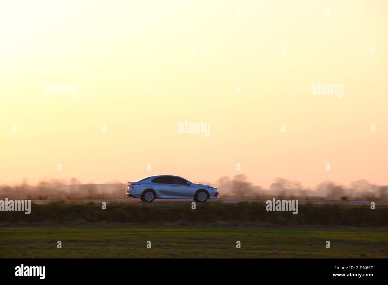 Car driving fast on intercity road at sunset. Highway traffic in ...
