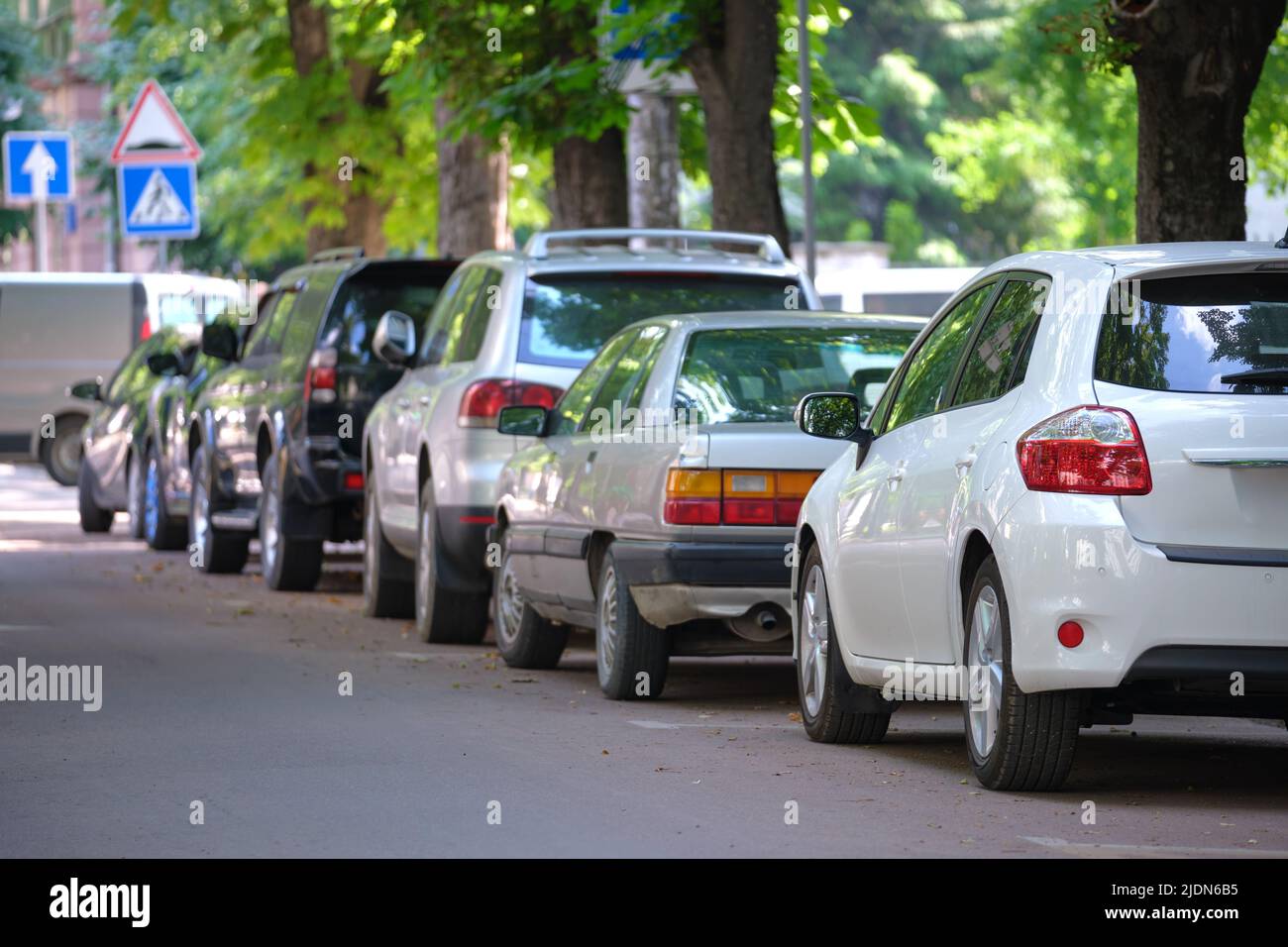 City traffic with cars parked in line on street side Stock Photo - Alamy