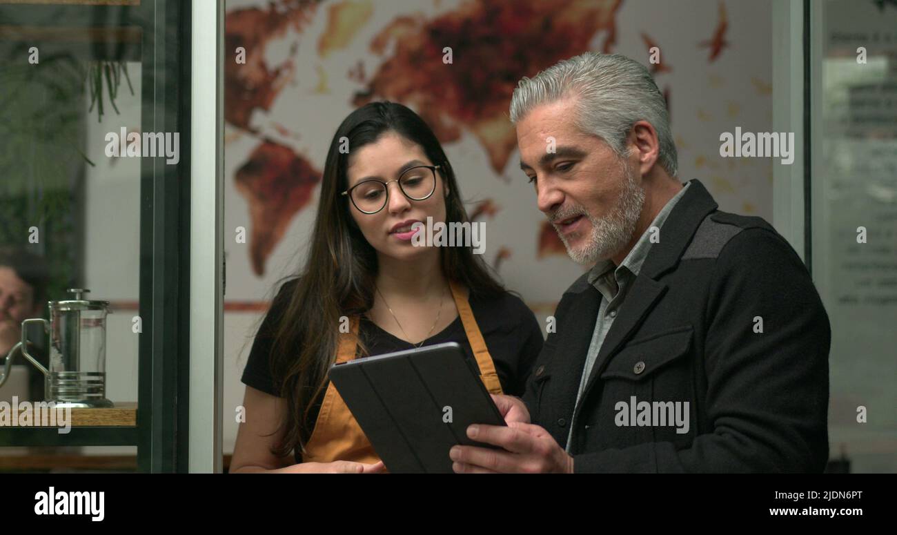 Business entrepreneur talking with coffee shop employee. Older male ...