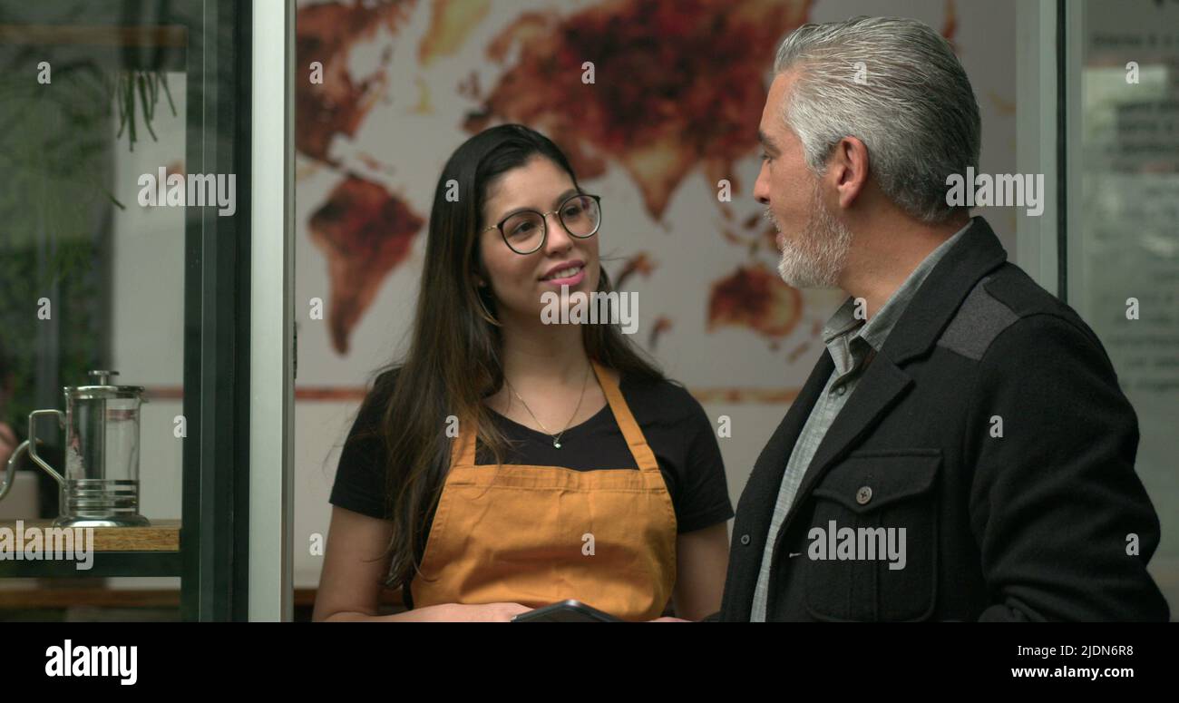 Business entrepreneur talking with coffee shop employee. Older male ...