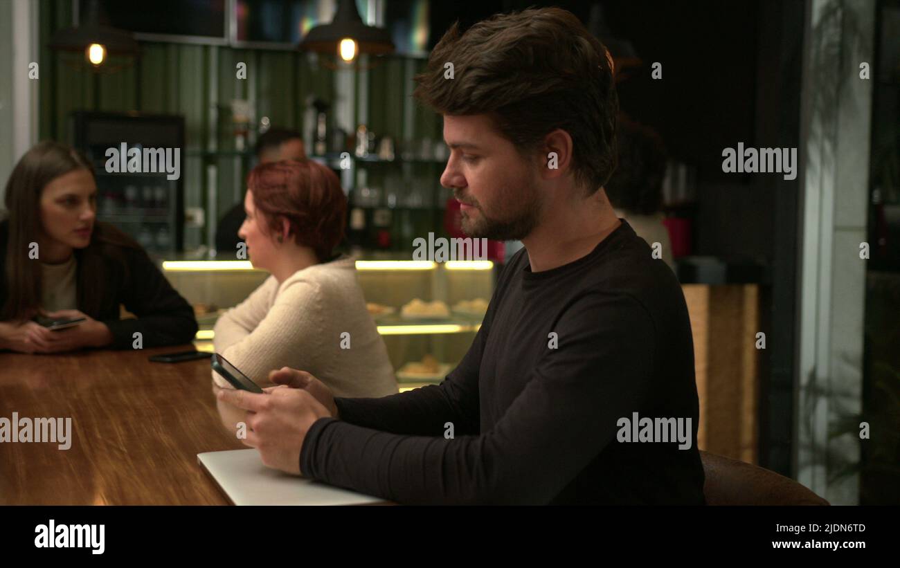 Young man doing his work inside coffee shop studying or working in ...