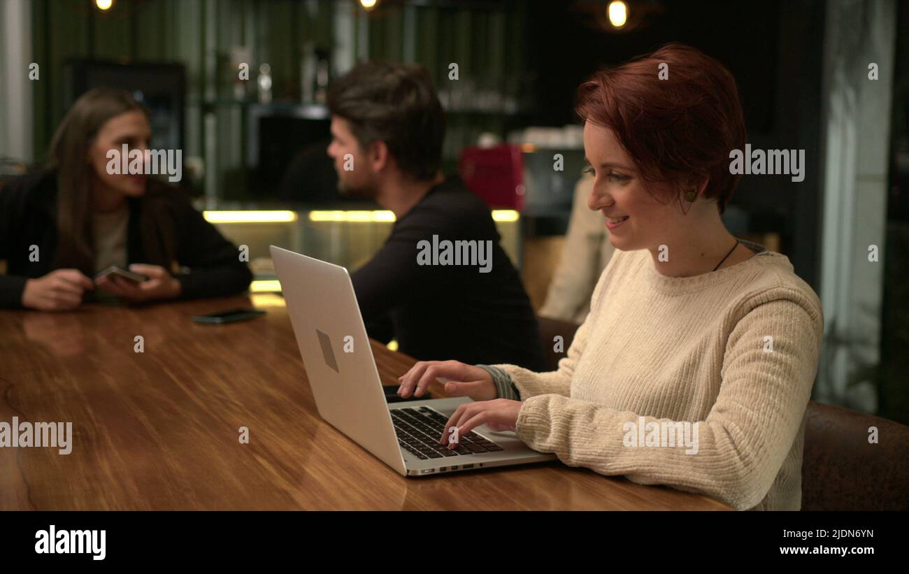 One happy millennial woman using laptop computer at cafe smiling ...