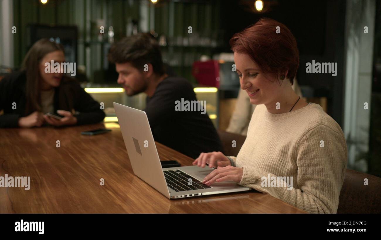 One happy millennial woman using laptop computer at cafe smiling ...
