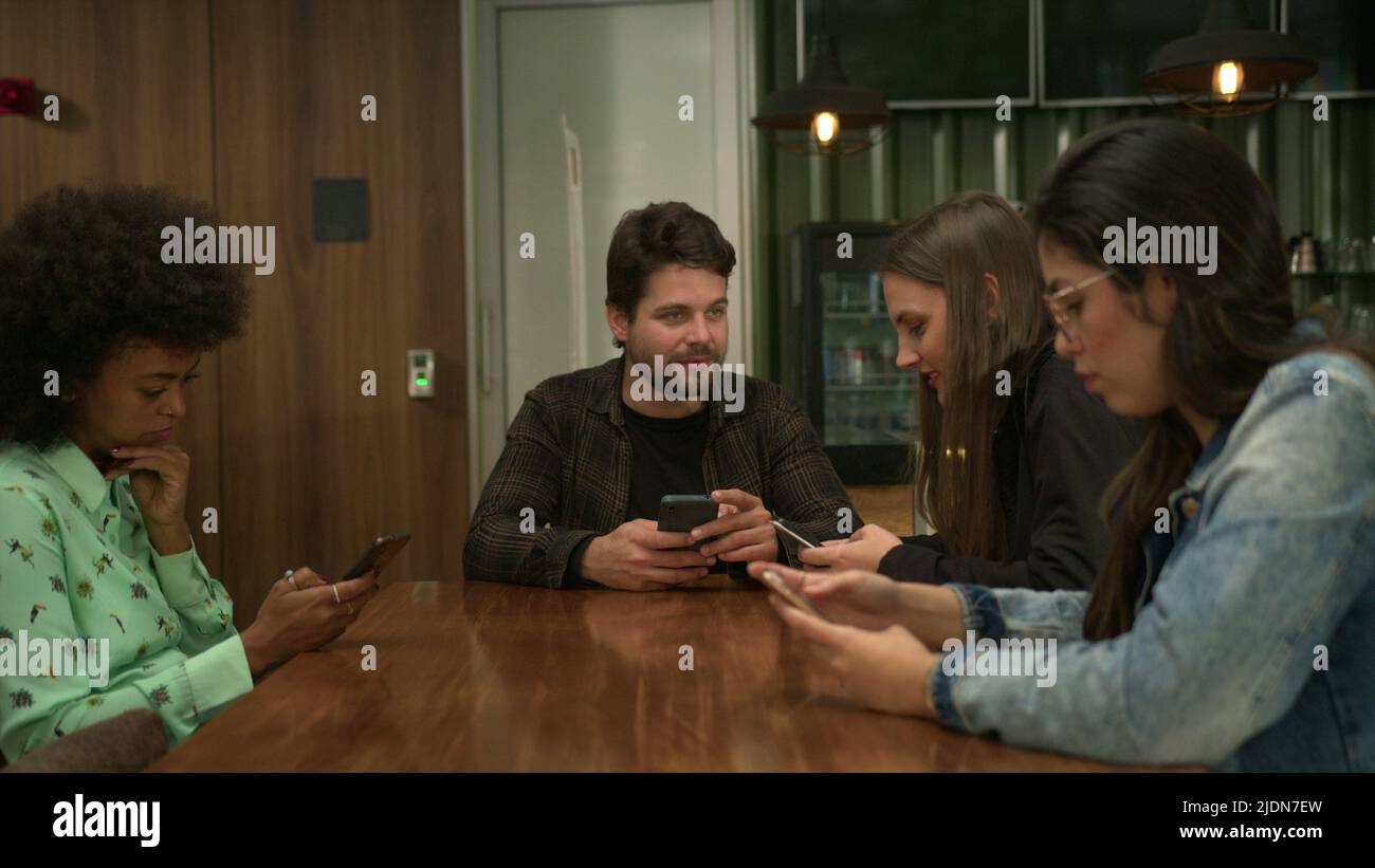 Group of young people using cellphones inside coffee shop. millennial ...