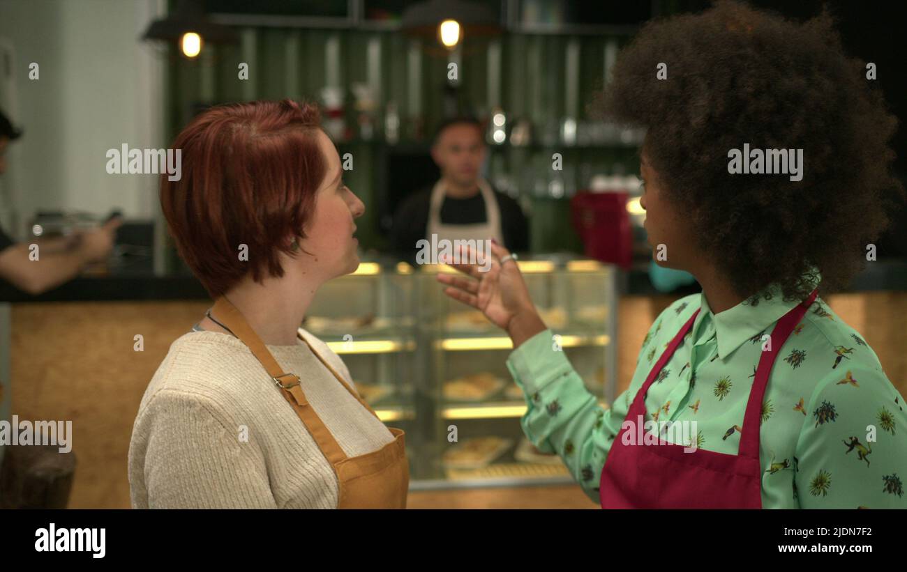 Female manager explaining small business Coffee shop to new employee ...