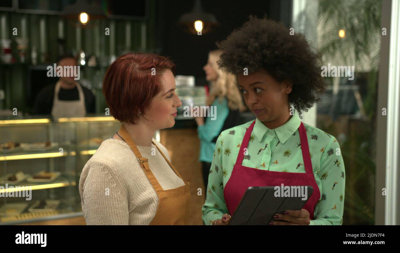 Female manager explaining small business Coffee shop to new employee ...