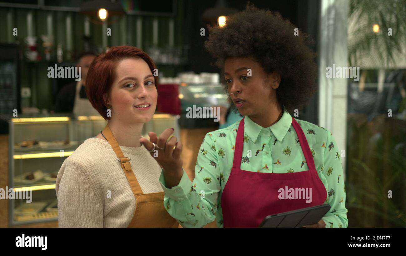 Female manager explaining small business Coffee shop to new employee ...