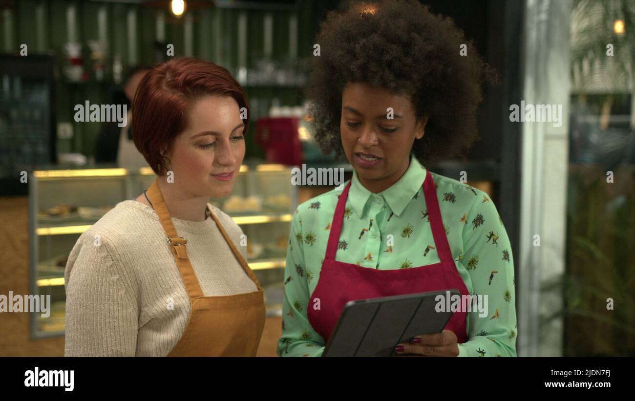 Female manager explaining small business Coffee shop to new employee ...