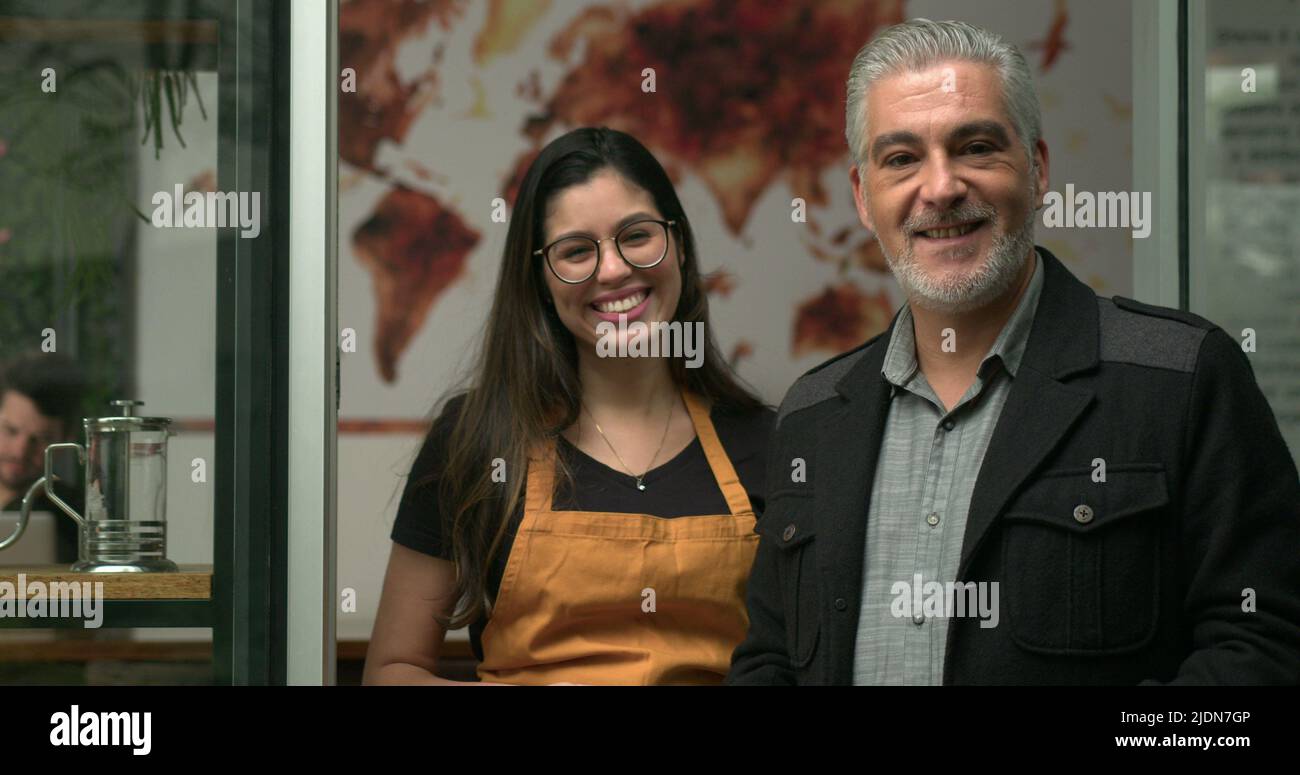 Male manager entrepreneur posing to camera with young female employee ...