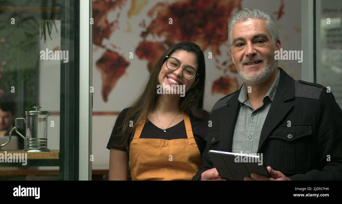 Male manager entrepreneur posing to camera with young female employee ...