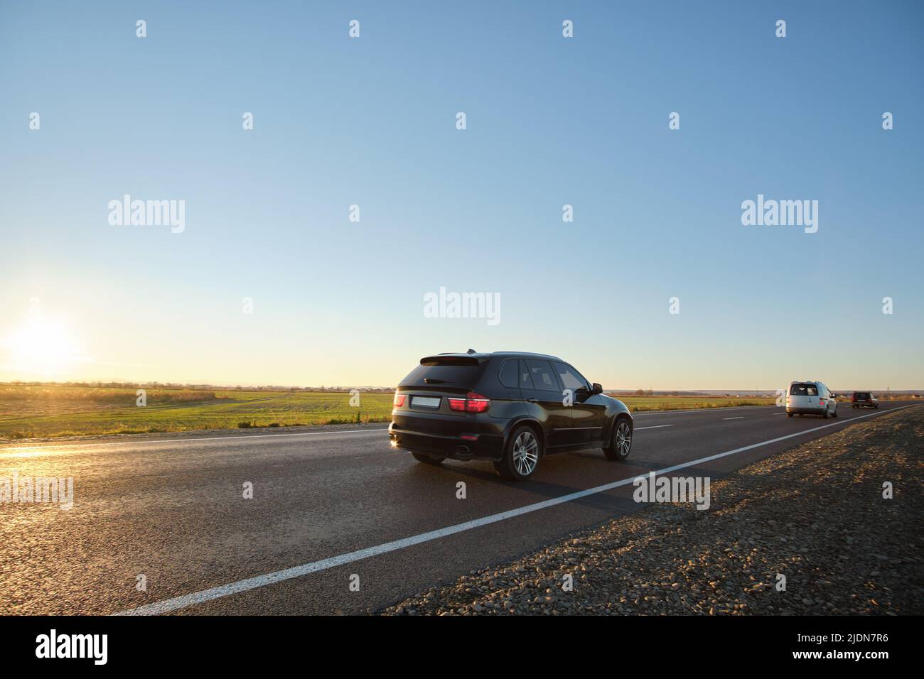 SUV car driving fast on intercity road at sunset. Highway traffic in ...