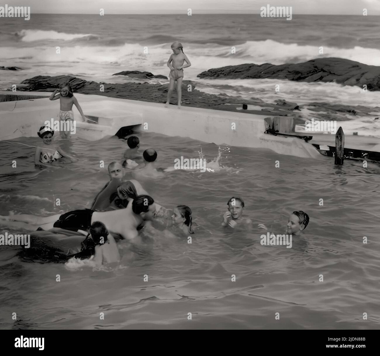 People swimming in a saltwater pool on the coast at Teshie in Accra ...