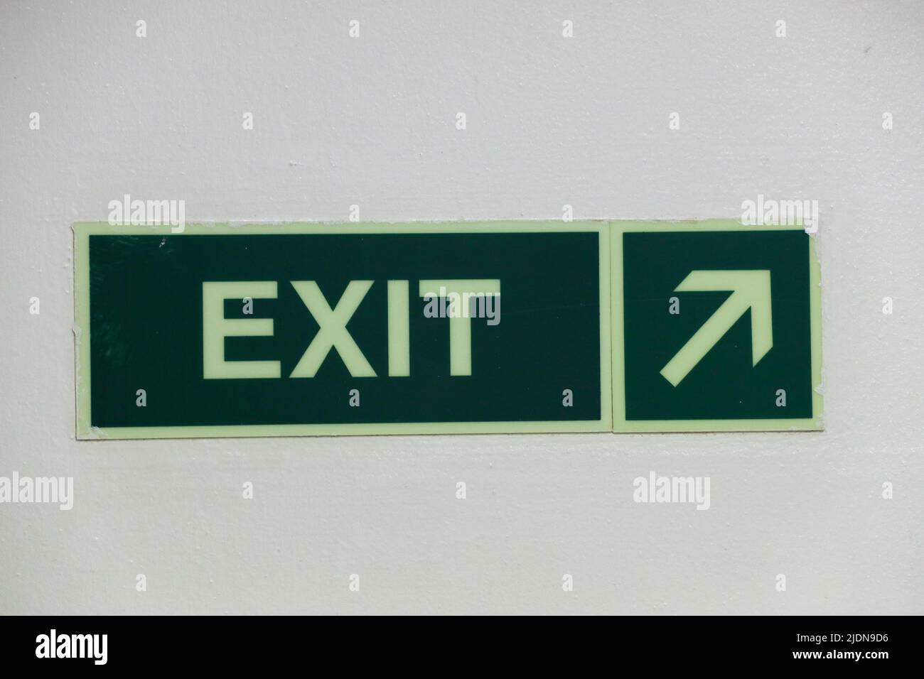 Green emergency exit sign on white Stock Photo - Alamy