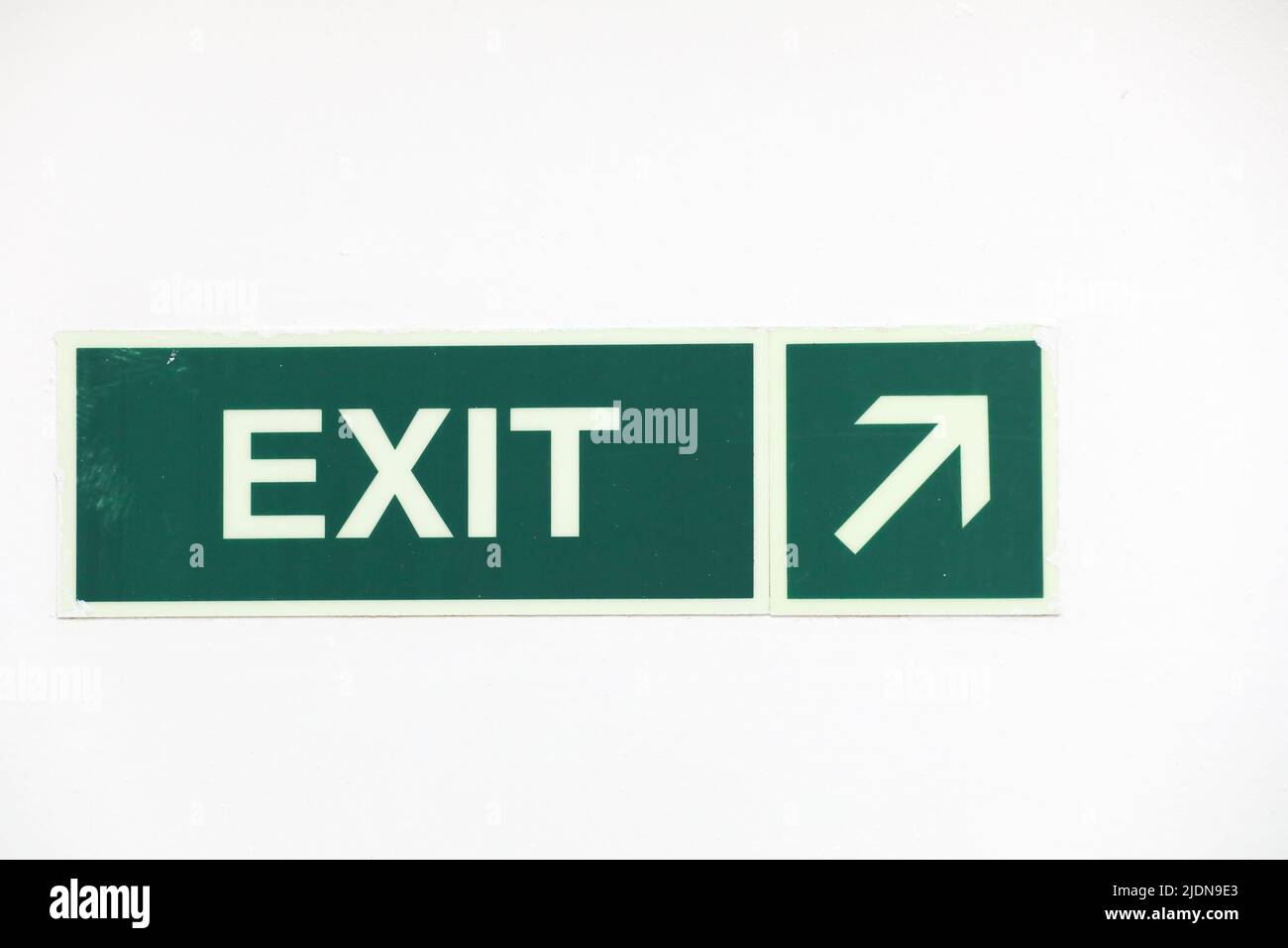 Green emergency exit sign on white Stock Photo - Alamy