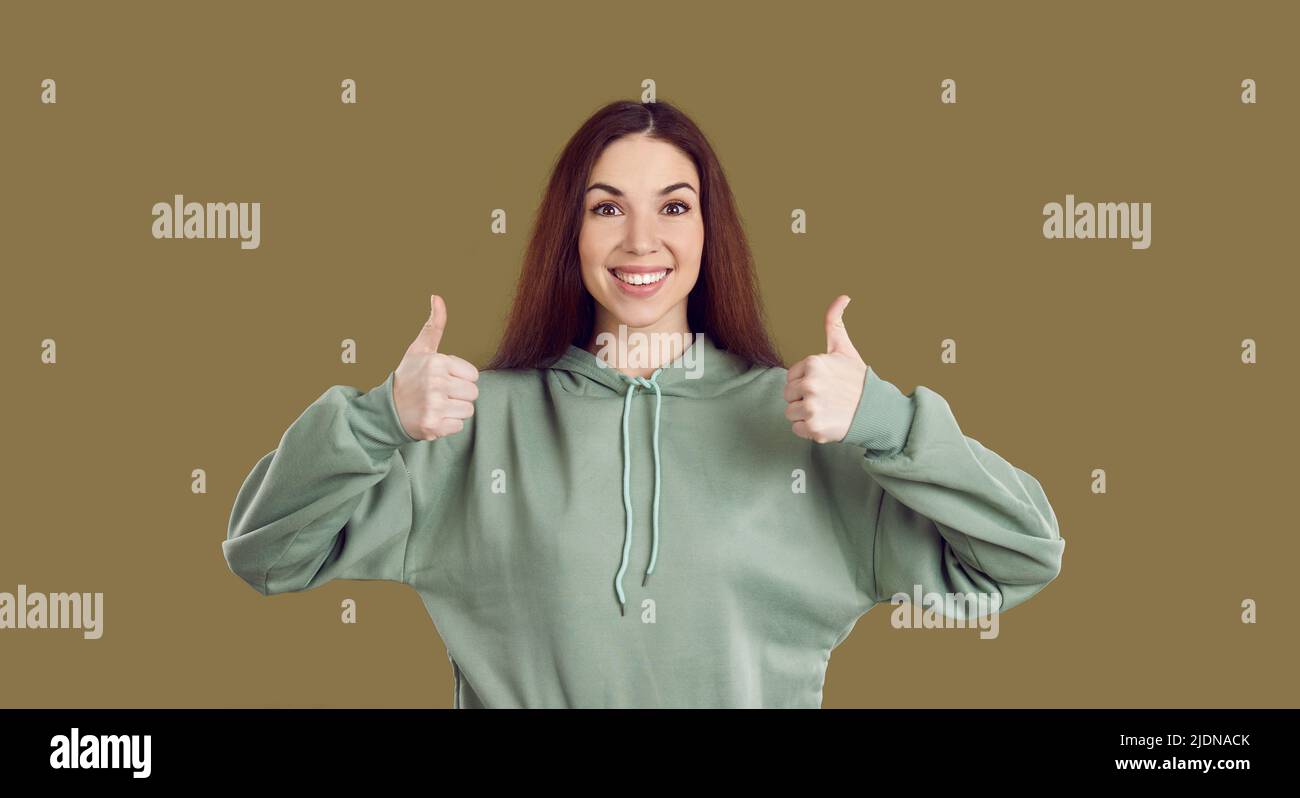 Happy young female customer raises thumbs up recommending products ...