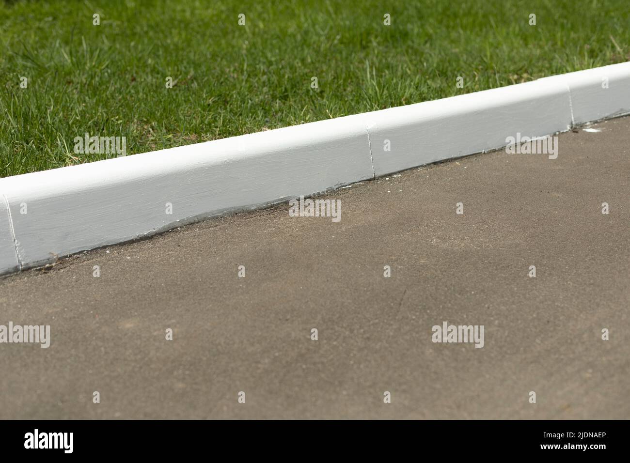White curb on road. Landscaping in park. Painted curb Stock Photo - Alamy