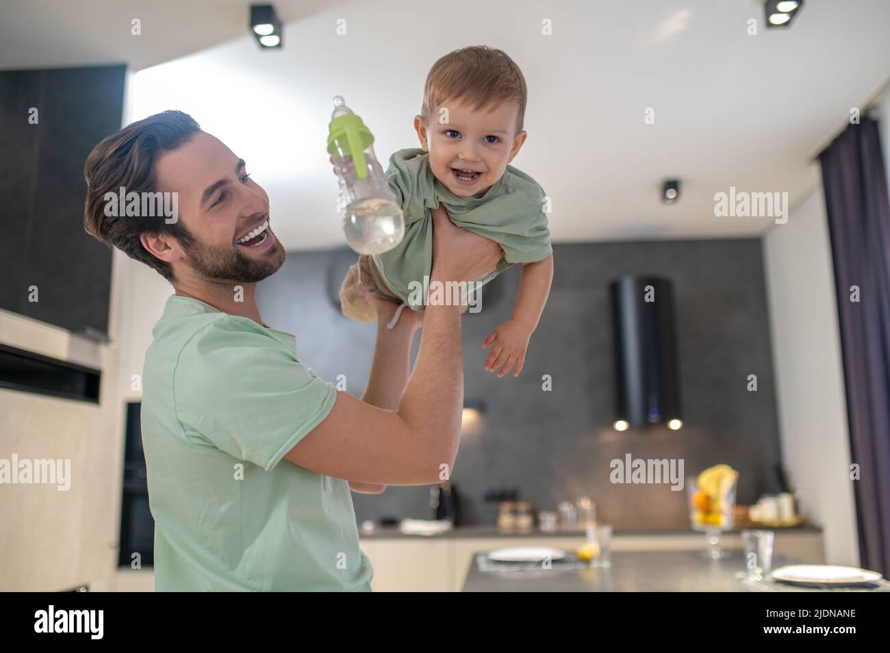 Young father spending time with his cute babyboy and looking happy ...