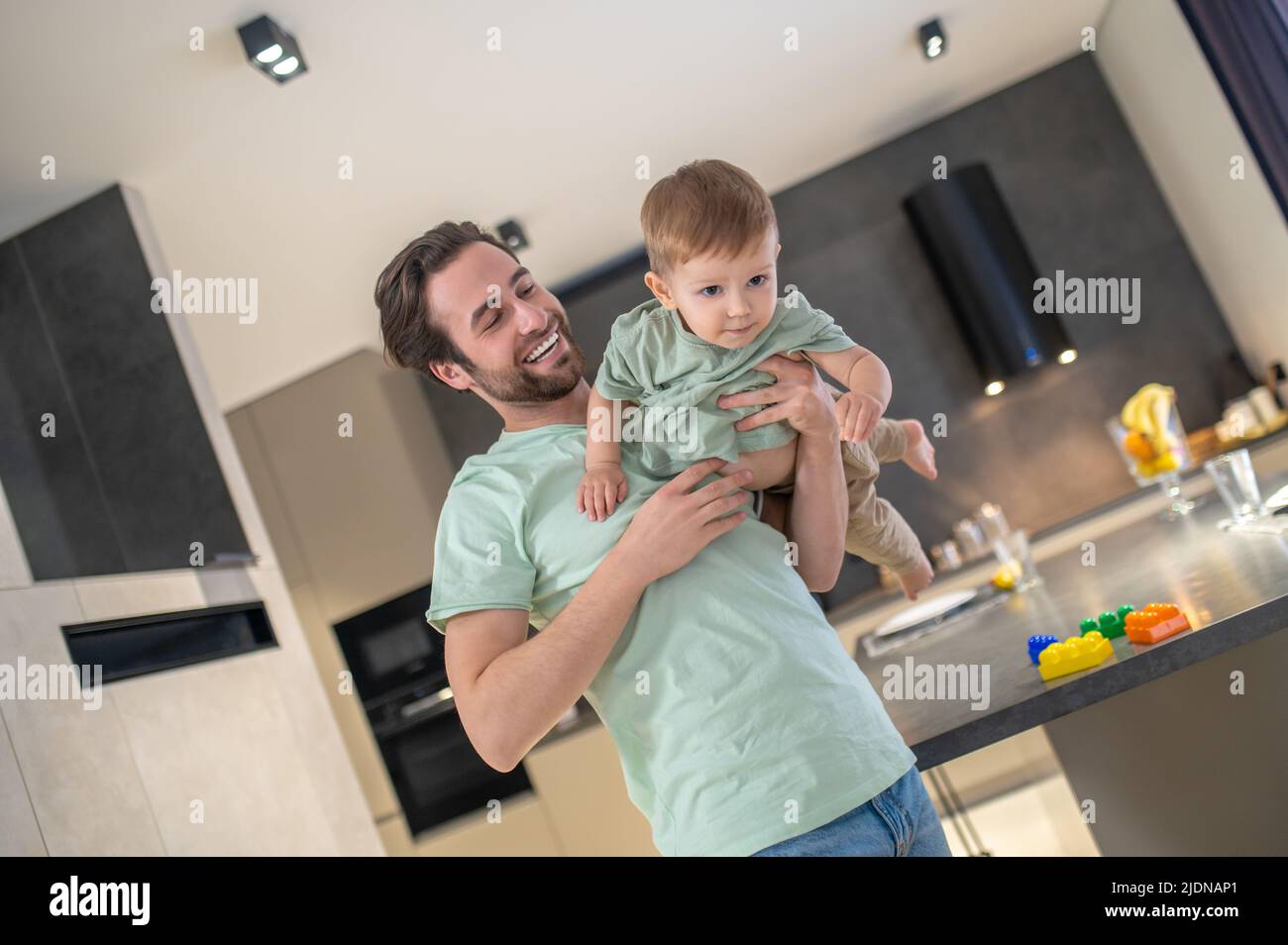 Young father spending time with his cute babyboy and looking happy ...