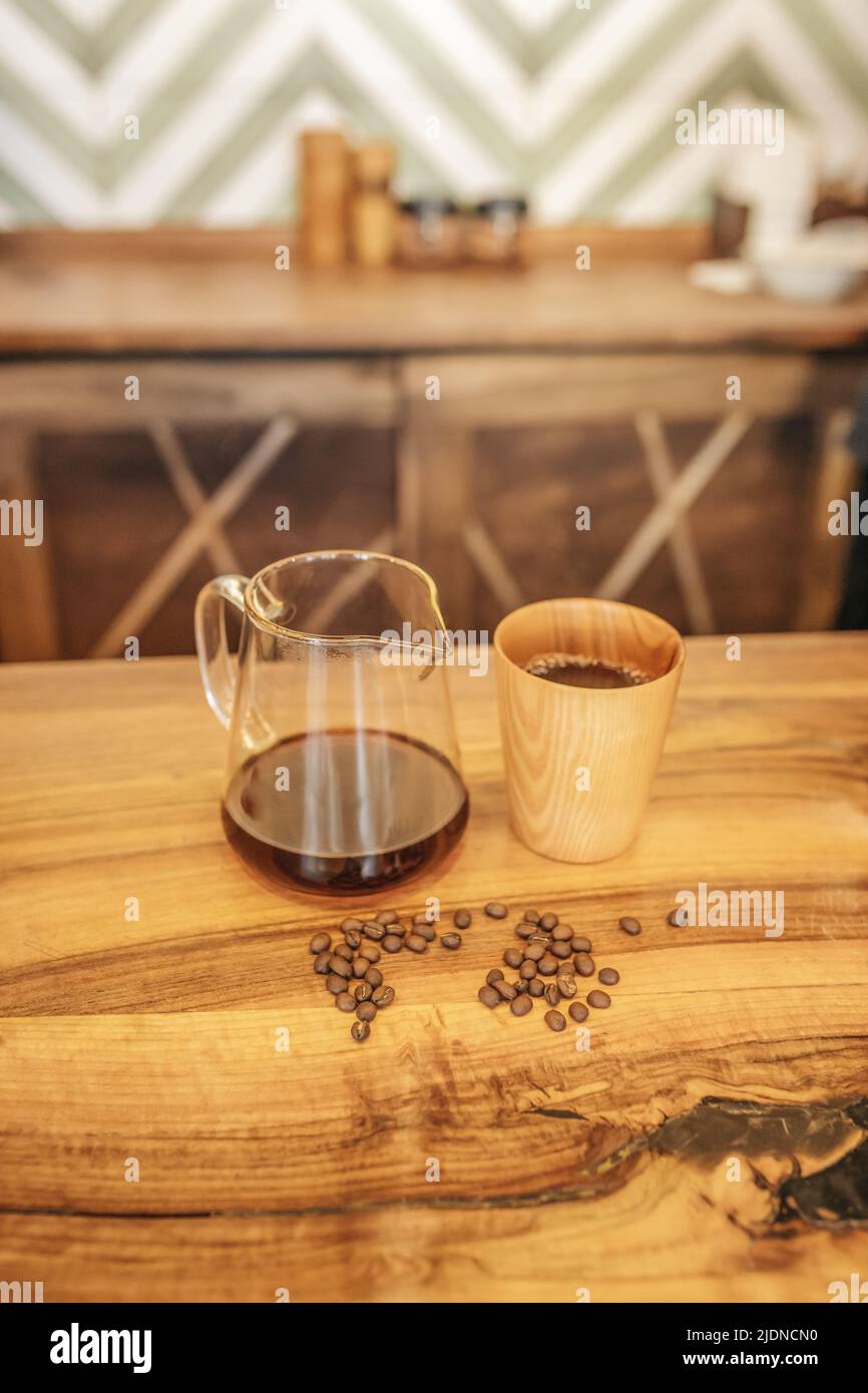 Jug cup with coffee and coffee beans on table Stock Photo - Alamy