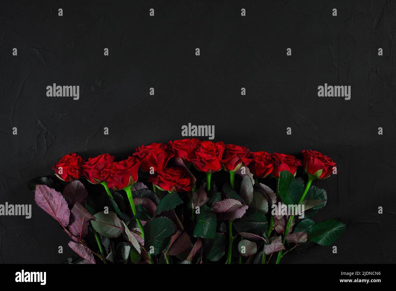 Bouquet of red roses on a black background. Top view Stock Photo - Alamy