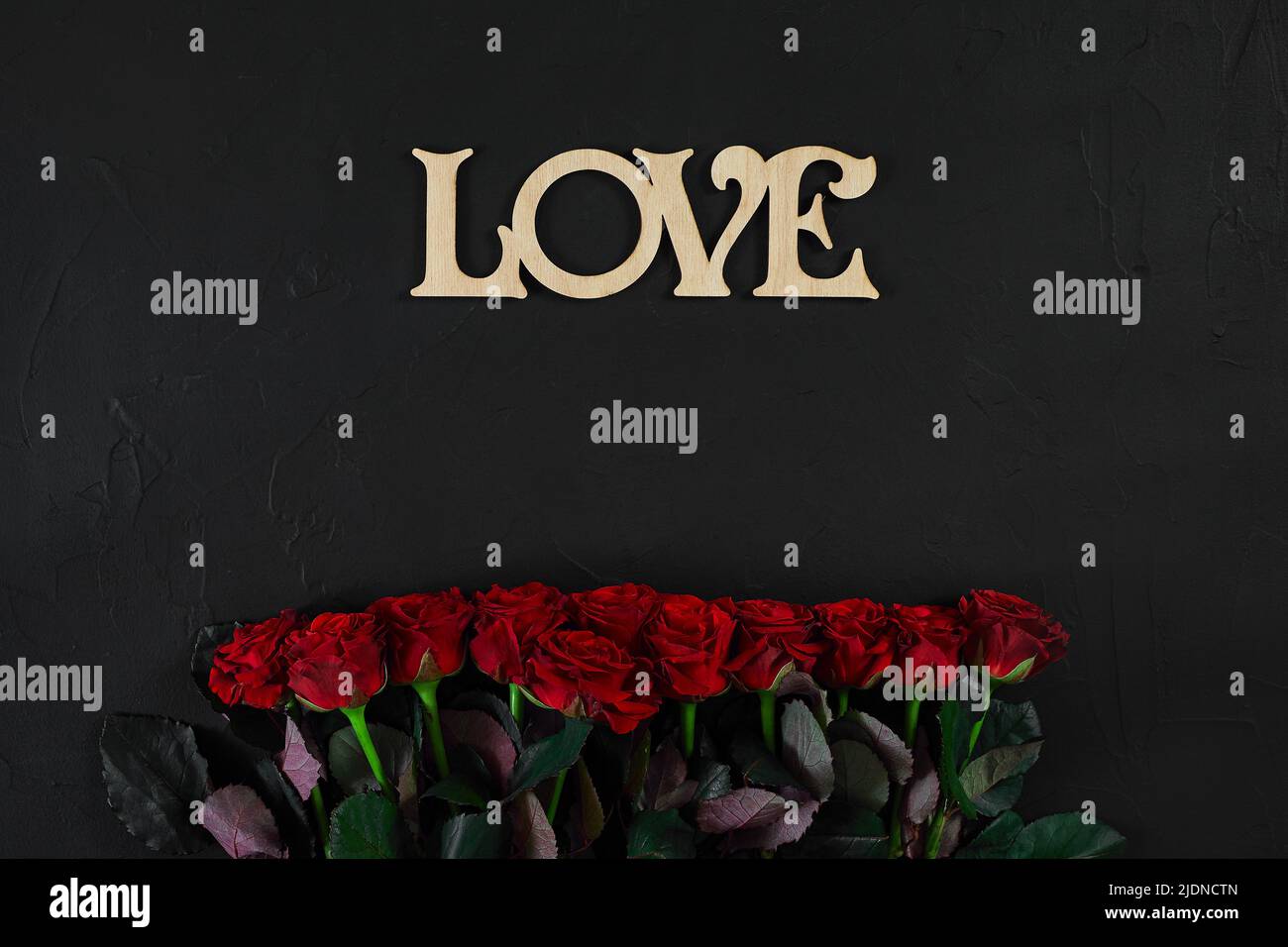 Red roses flowers with wooden word LOVE on black background with Stock ...