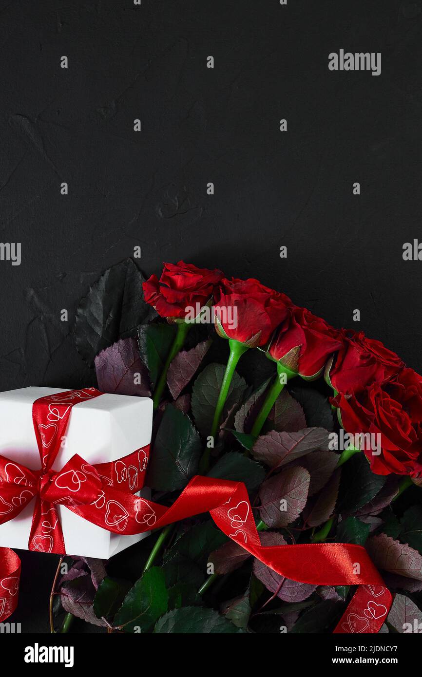 Top view fresh red rose flower and gift box on black deck with e Stock ...