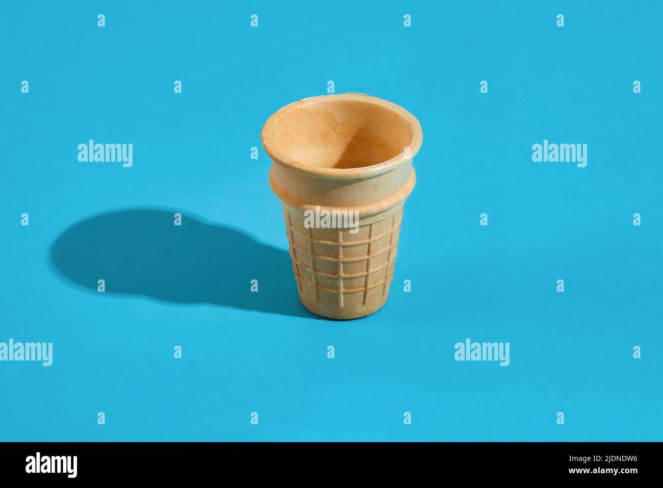 Waffle ice cream cones with shadow on a blue background. Still life ...