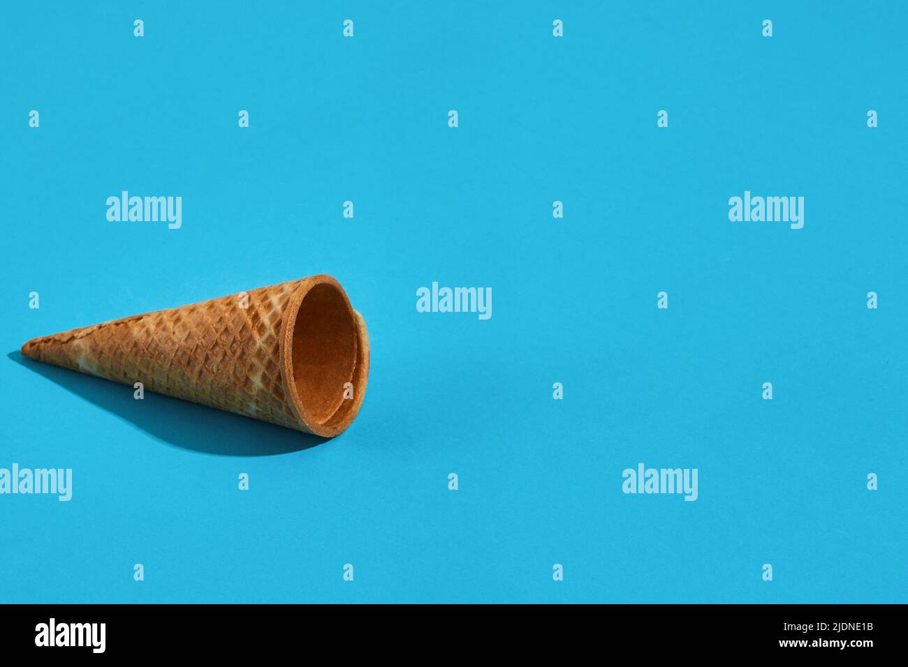 Waffle ice cream cones with shadow on a blue background. Still life ...