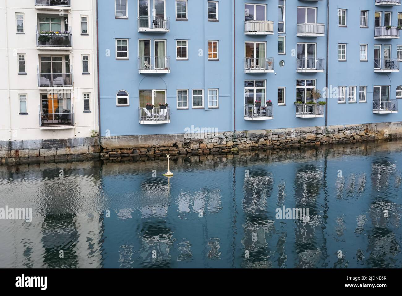 Blue and white buildings reflected in the water in the Norwegian town ...