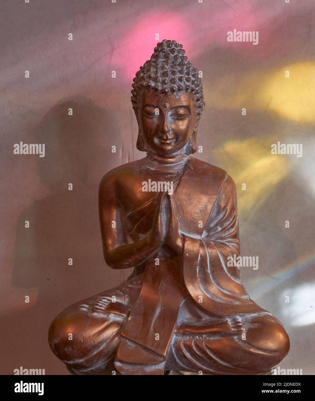 Golden buddha statuette with hands folded like the Indian Namaste ...