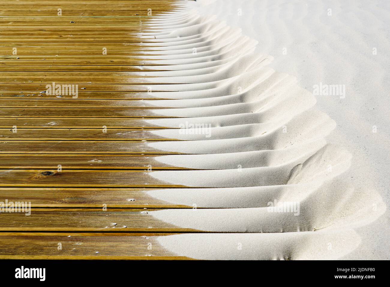 Wind created pattern of light fine beach sand on brown outdoor patio ...