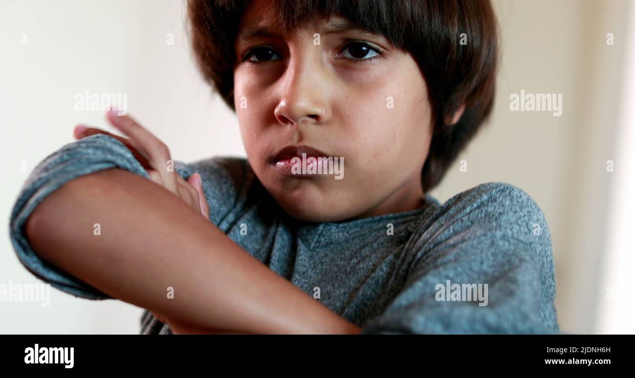 Angry child reaction crossing arms in anger. Offended young boy with ...