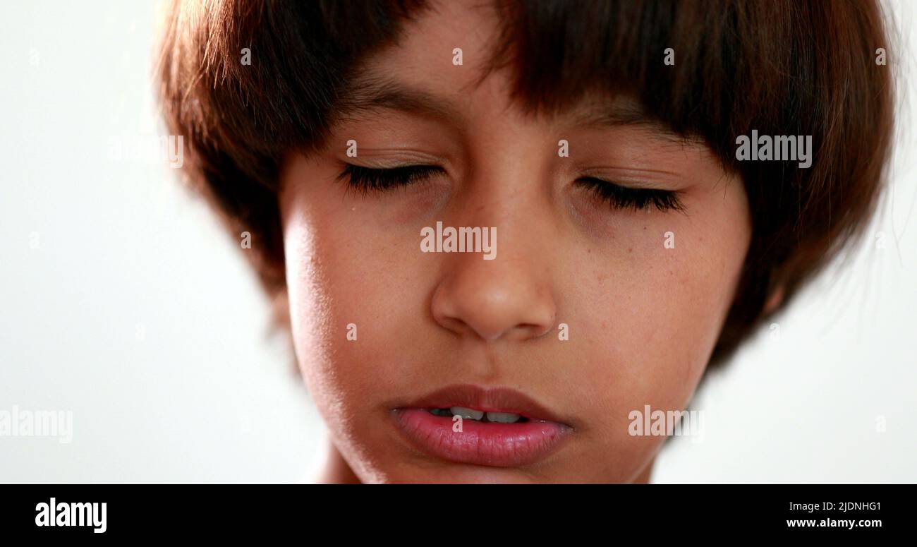 Boy praying to God with hands held together. Mixed race child prays ...