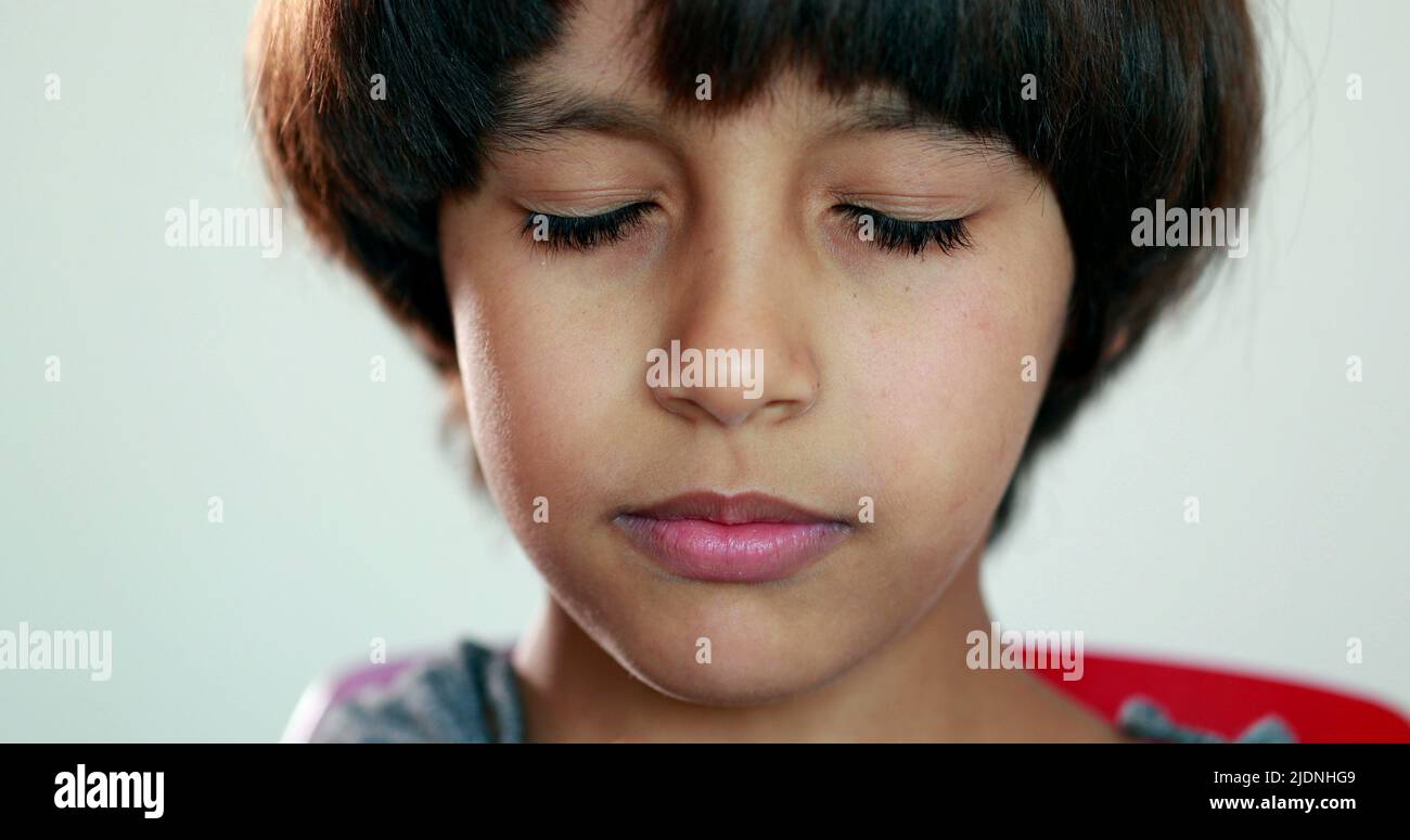 Boy close-up face praying eyes closed, mixed race child contemplative ...