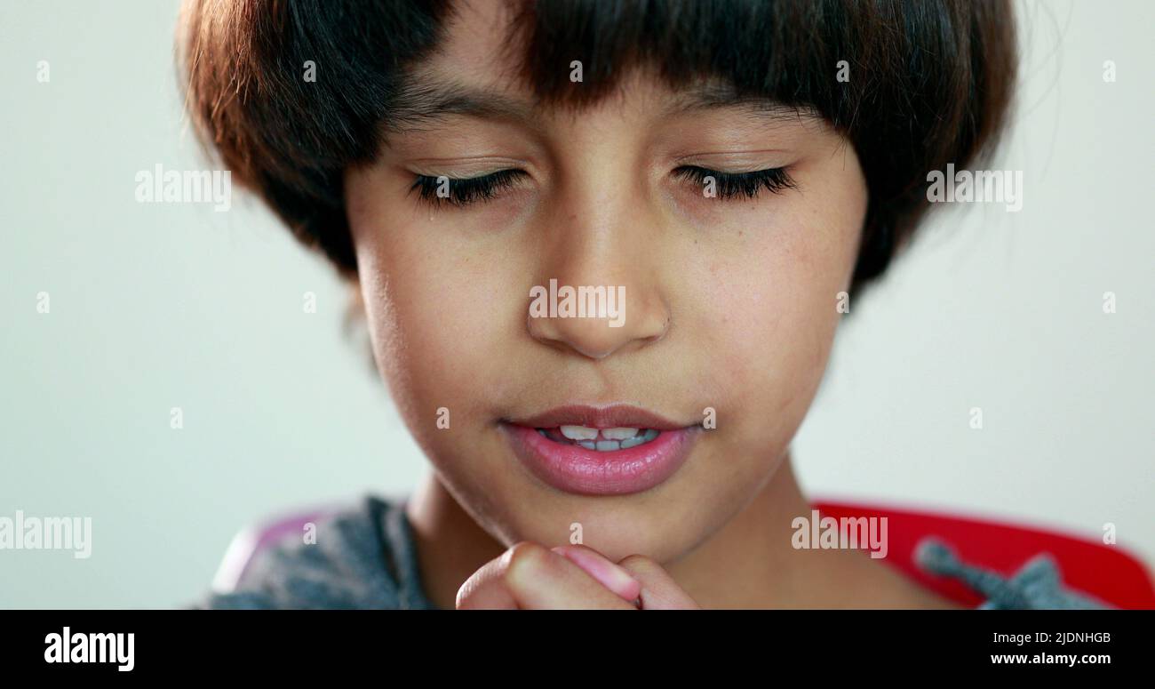 Boy close-up face praying eyes closed, mixed race child contemplative ...