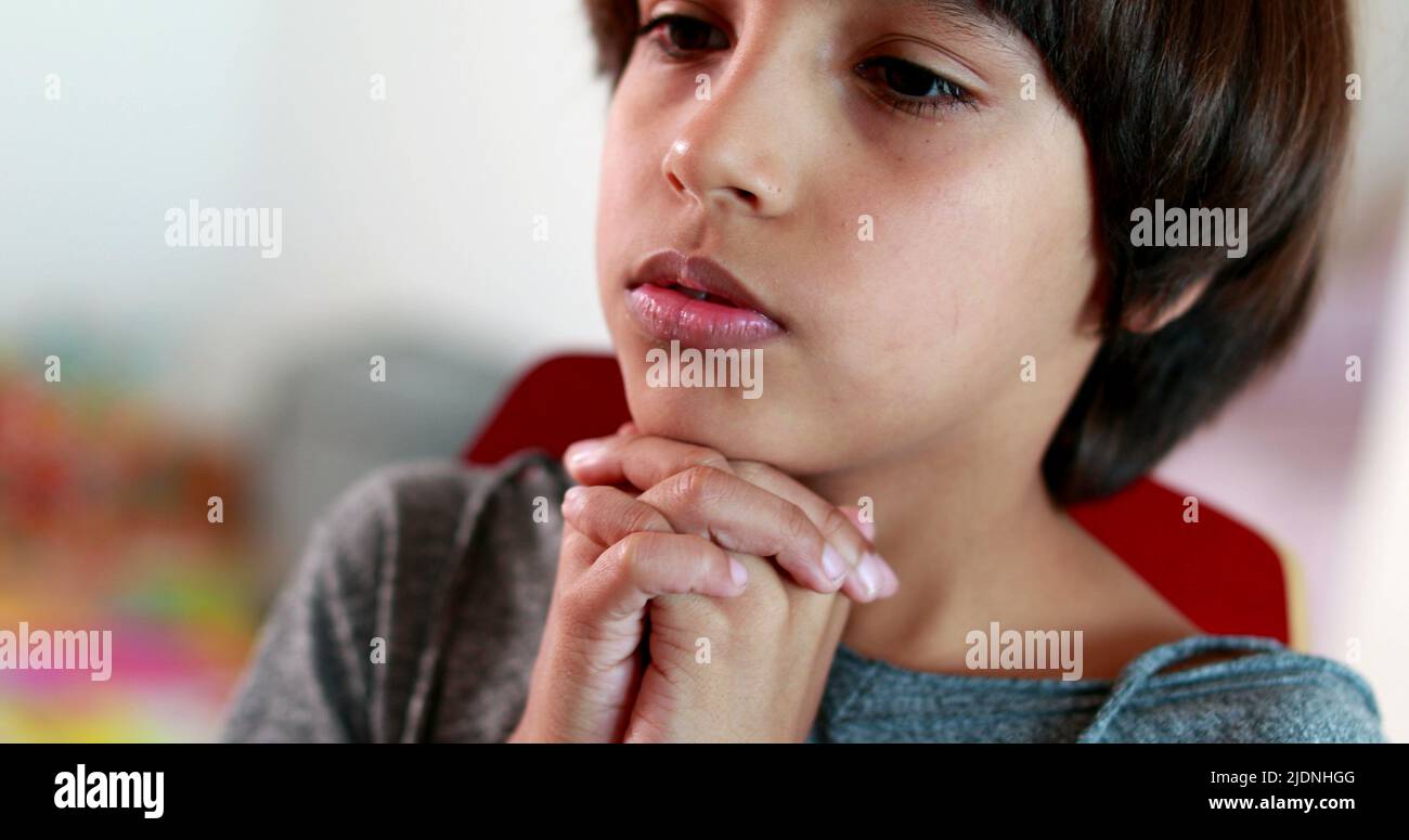 Boy praying to God with hands held together. Mixed race child prays ...
