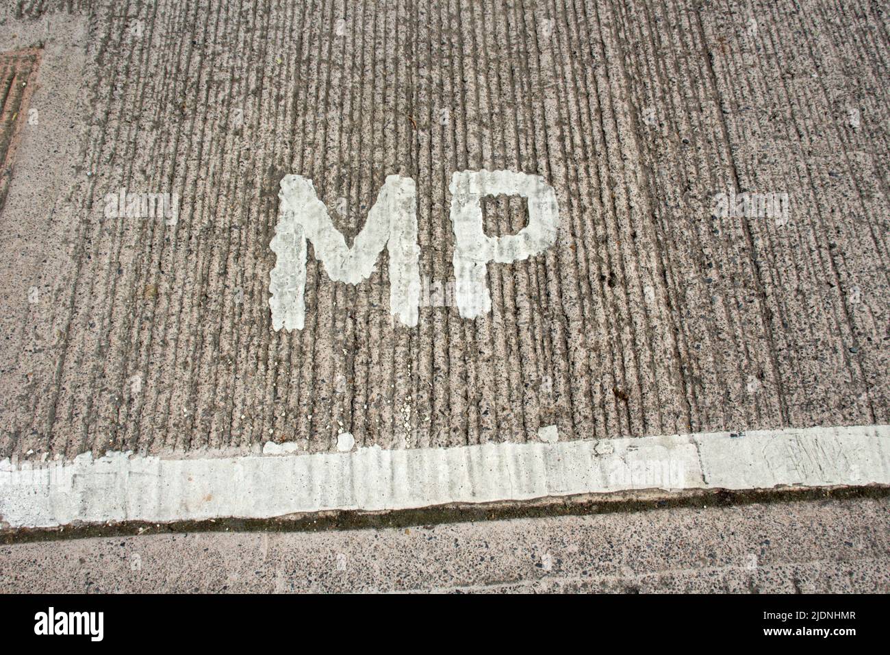 MP written in white paint on a grey cement parking space Stock Photo ...