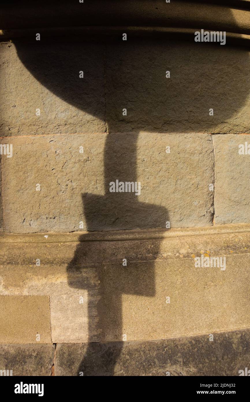 road sign shadow on a grey and yellow stone wall Stock Photo - Alamy