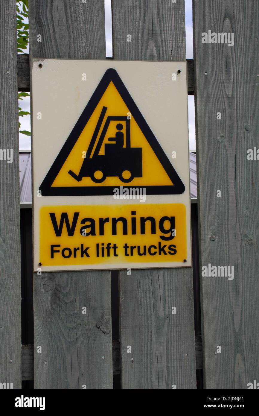 warning fork lift trucks sign in black letters on a yellow background ...